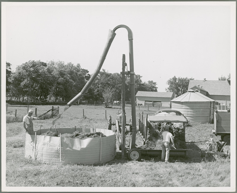 Two workers filling a temporary silo | Iowa State University Photographs